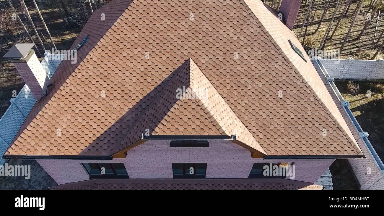 House with a roof from a bituminous tile. Bituminous tile for a roof. a ...