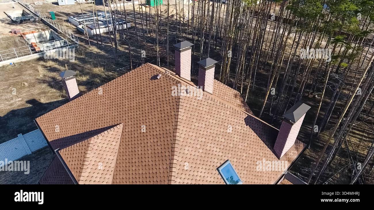 House with a roof from a bituminous tile. Bituminous tile for a roof. a ...