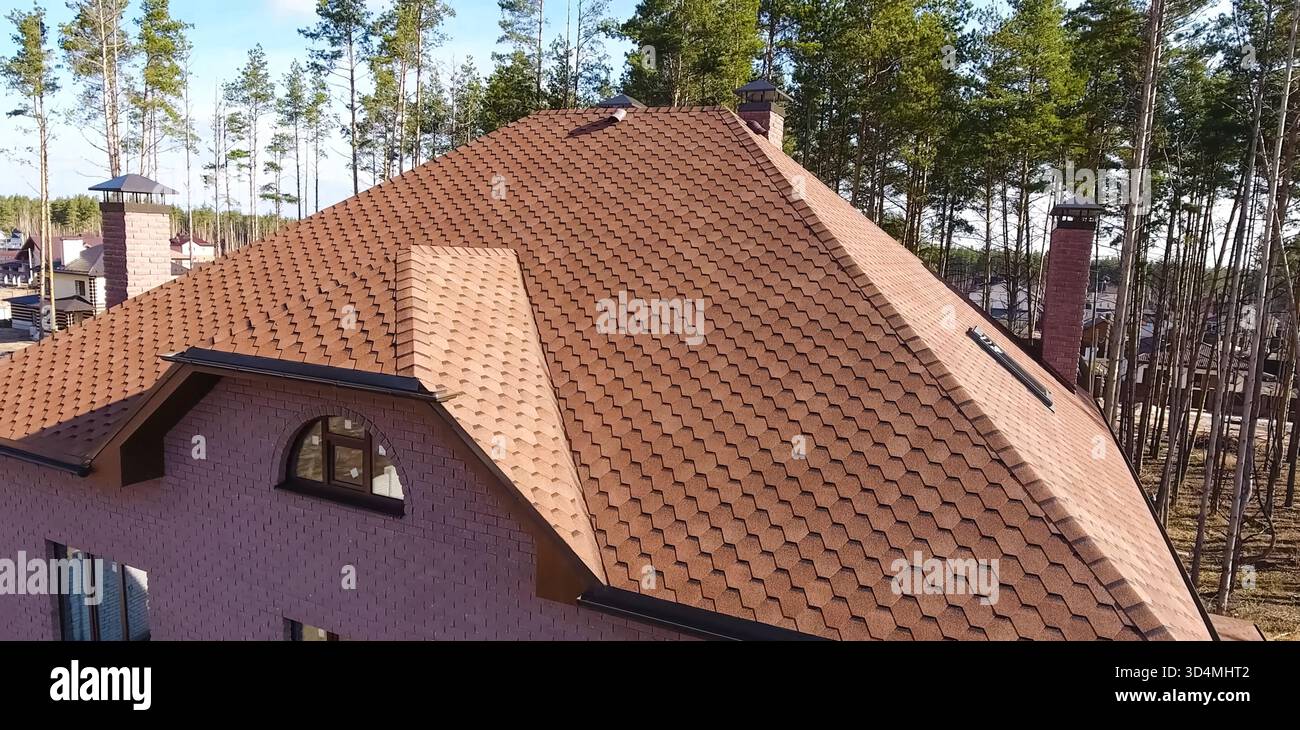 House with a roof from a bituminous tile. Bituminous tile for a roof. a ...