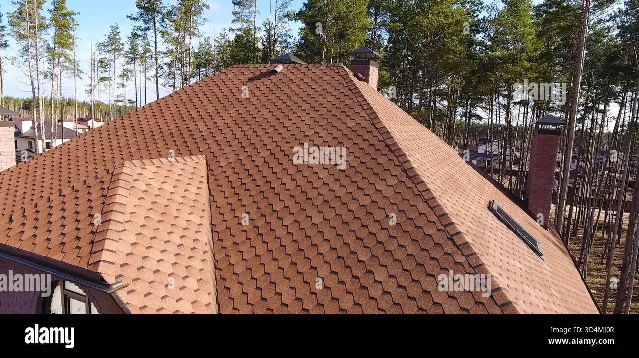 House with a roof from a bituminous tile. Bituminous tile for a roof. a ...