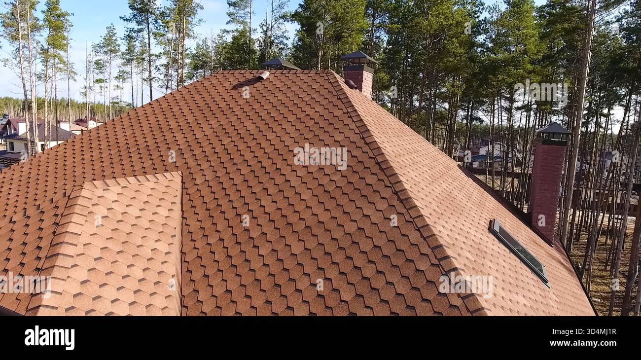 House with a roof from a bituminous tile. Bituminous tile for a roof. a ...