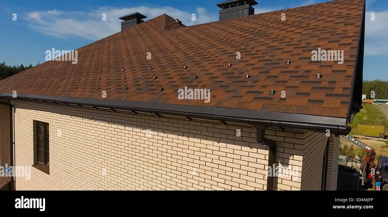 House with a roof from a bituminous tile. Bituminous tile for a roof. a ...