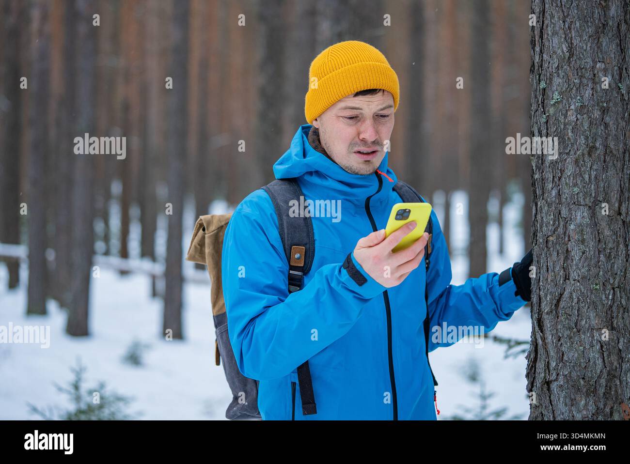 Man lost and panicking in snowy forest, solo hiker in yellow beanie ...