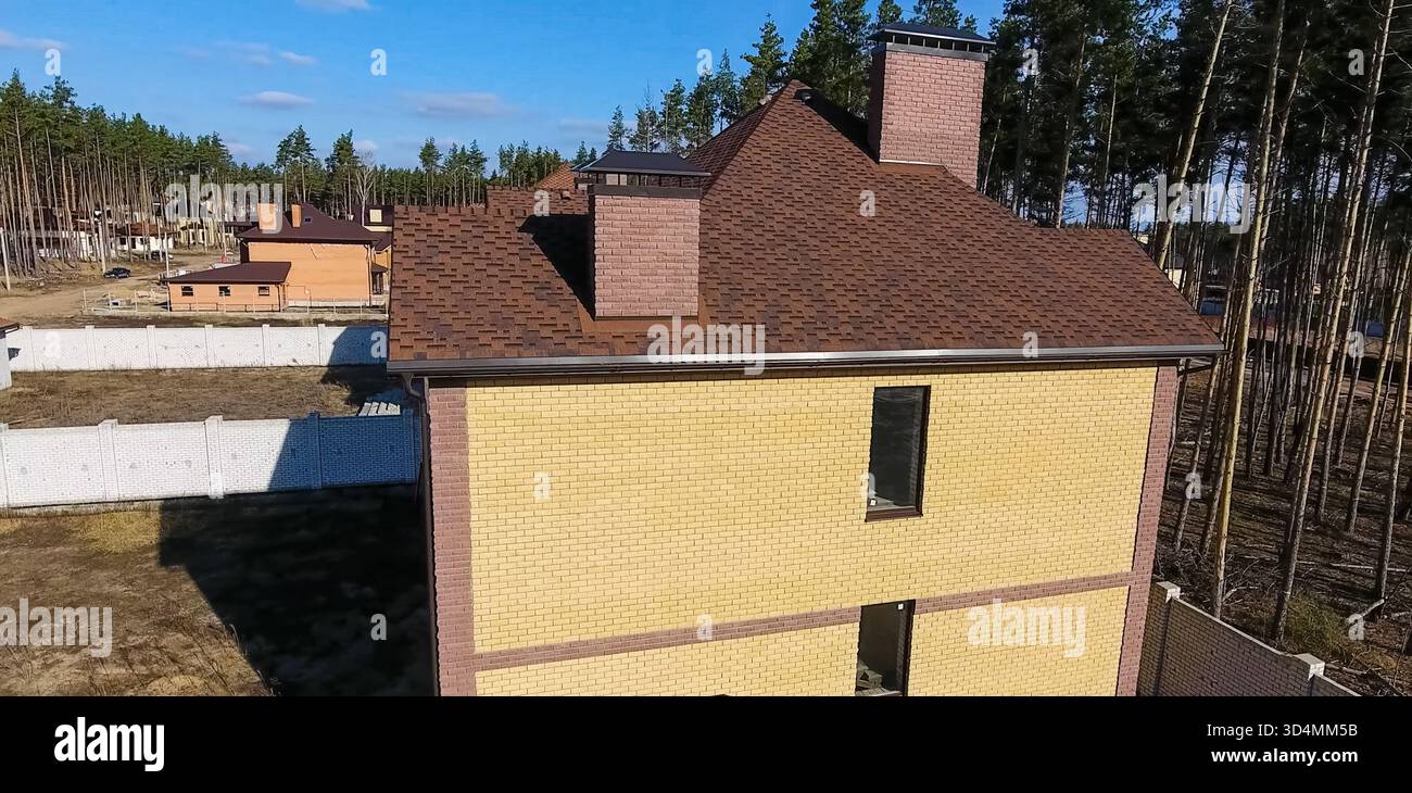House with a roof from a bituminous tile. Bituminous tile for a roof. a ...