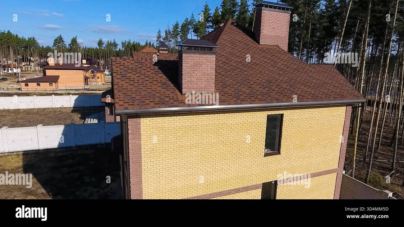 House with a roof from a bituminous tile. Bituminous tile for a roof. a ...