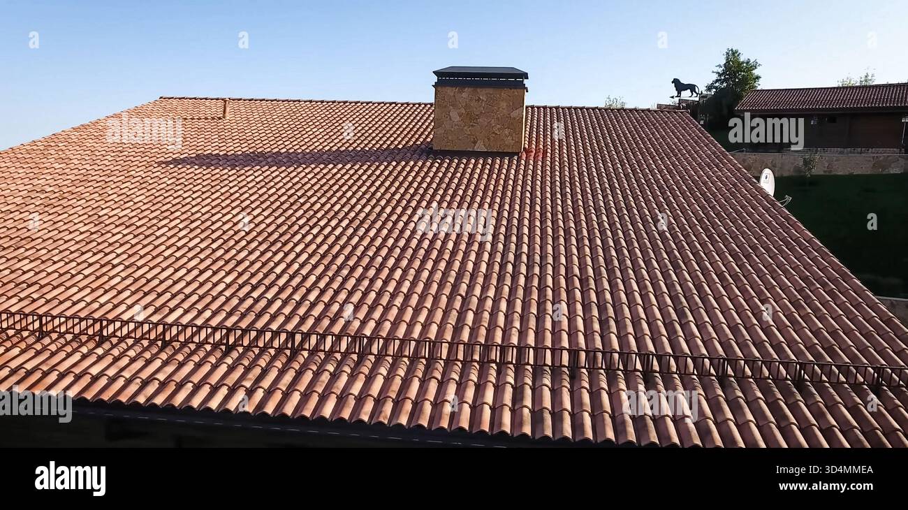 House with a ceramic tile roof. cement-sand roof tiles Stock Photo - Alamy