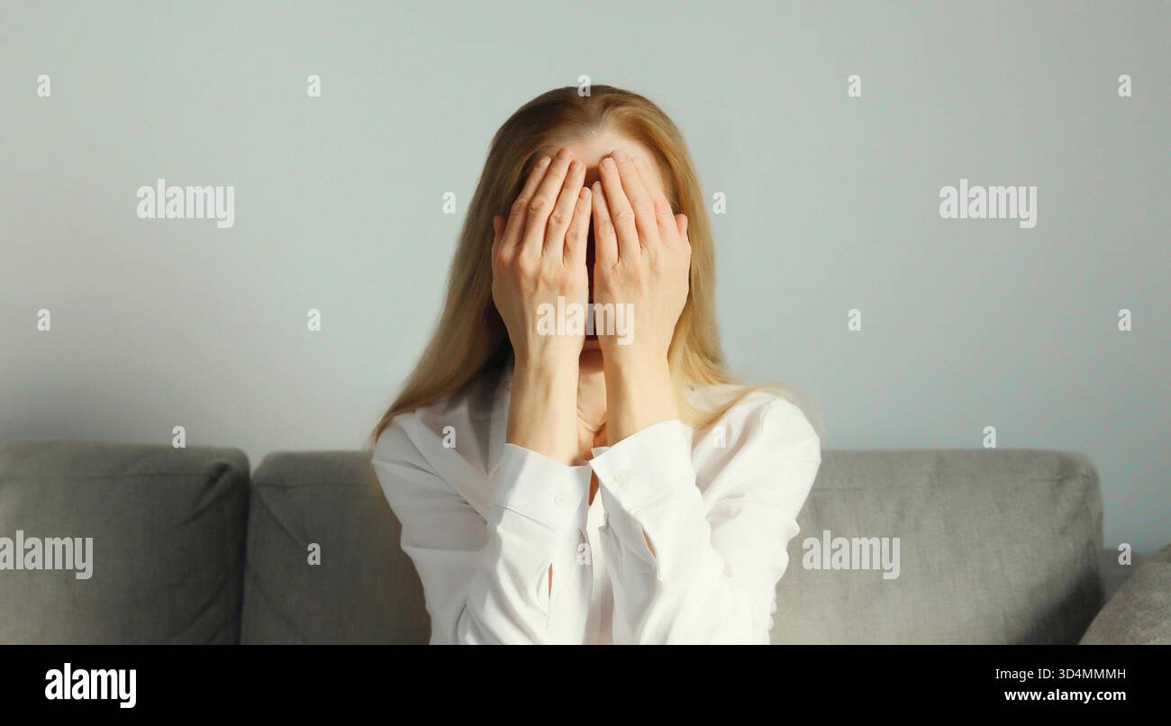 Upset sad crying woman covering her eyes and face with her hands while ...