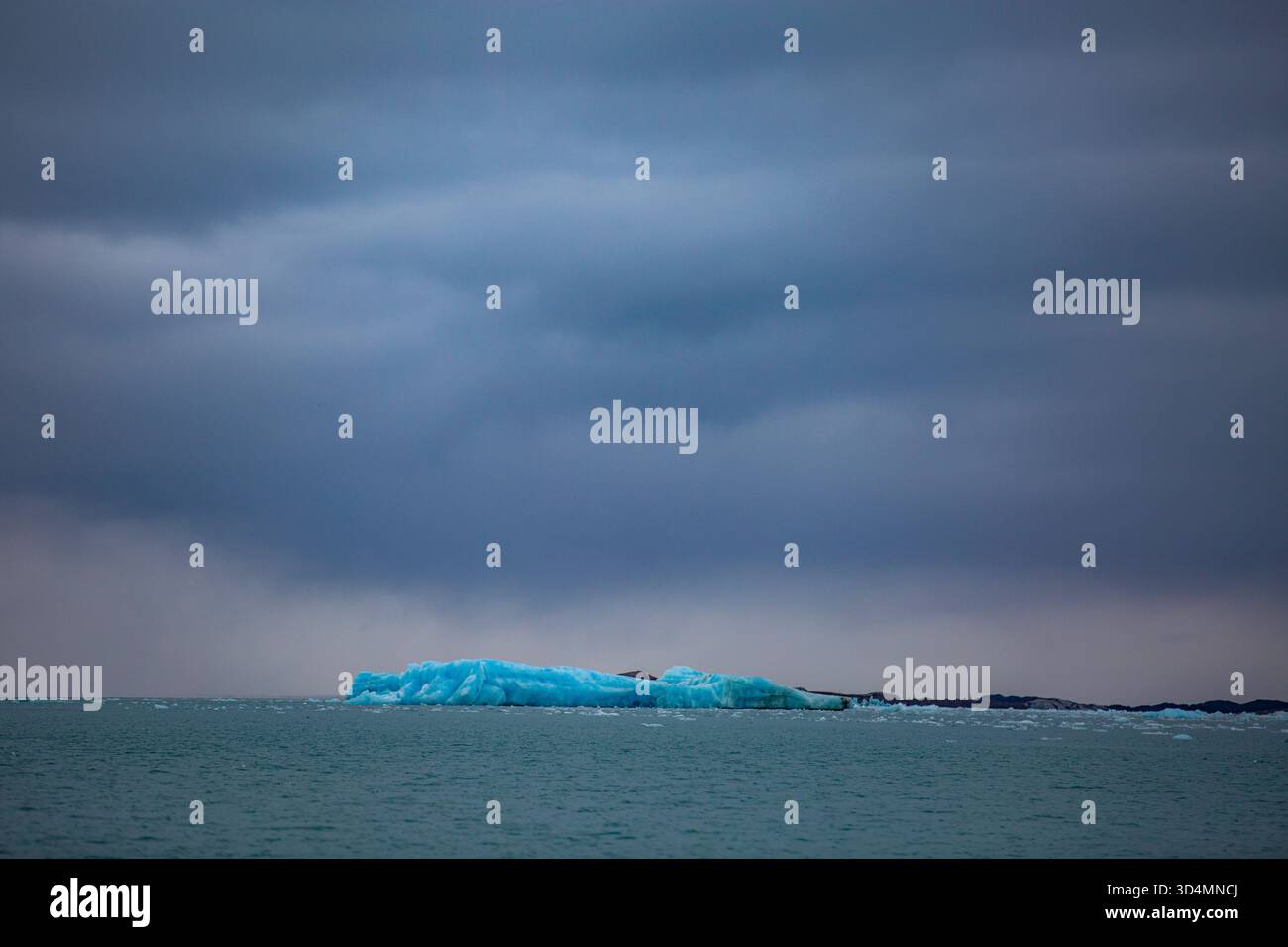 Svalbard cruise - Large iceberg is floating in the ocean. The sky is ...