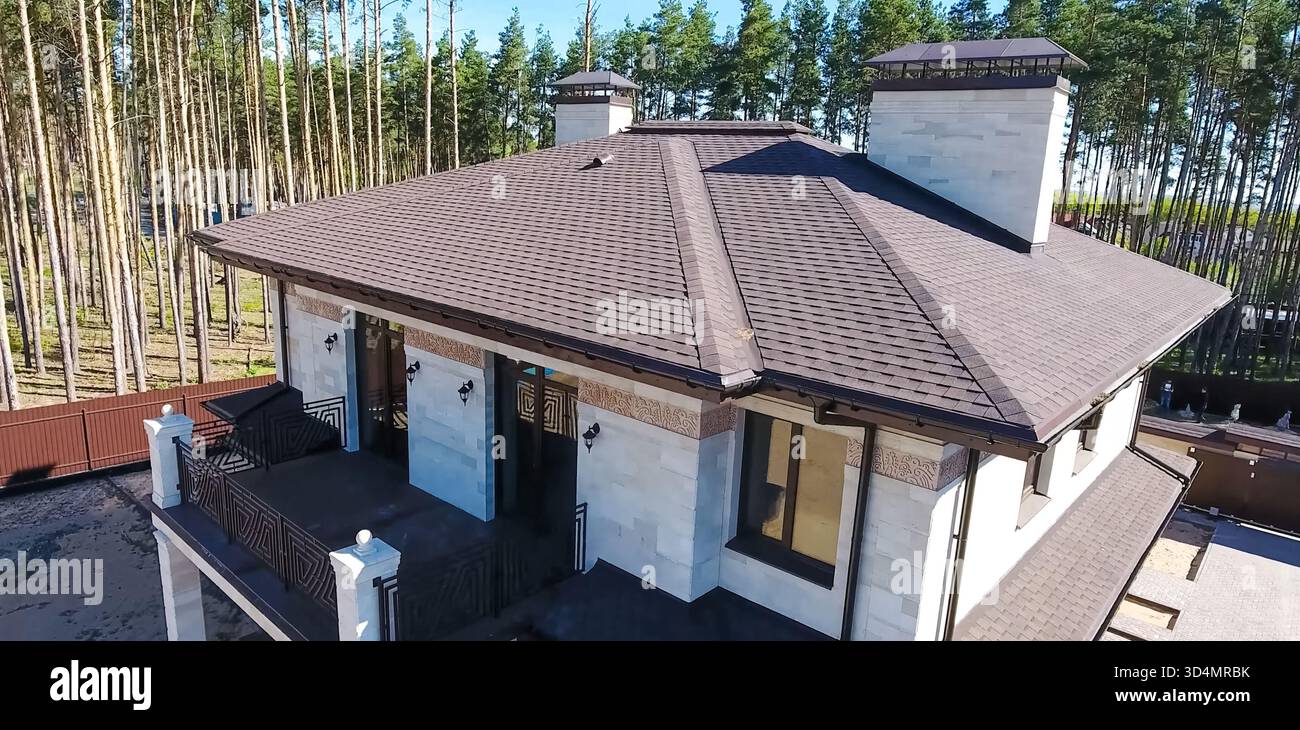 House with a roof from a bituminous tile. Bituminous tile for a roof. a ...