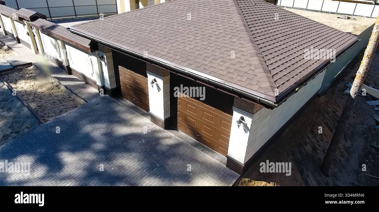 House with a roof from a bituminous tile. Bituminous tile for a roof. a ...