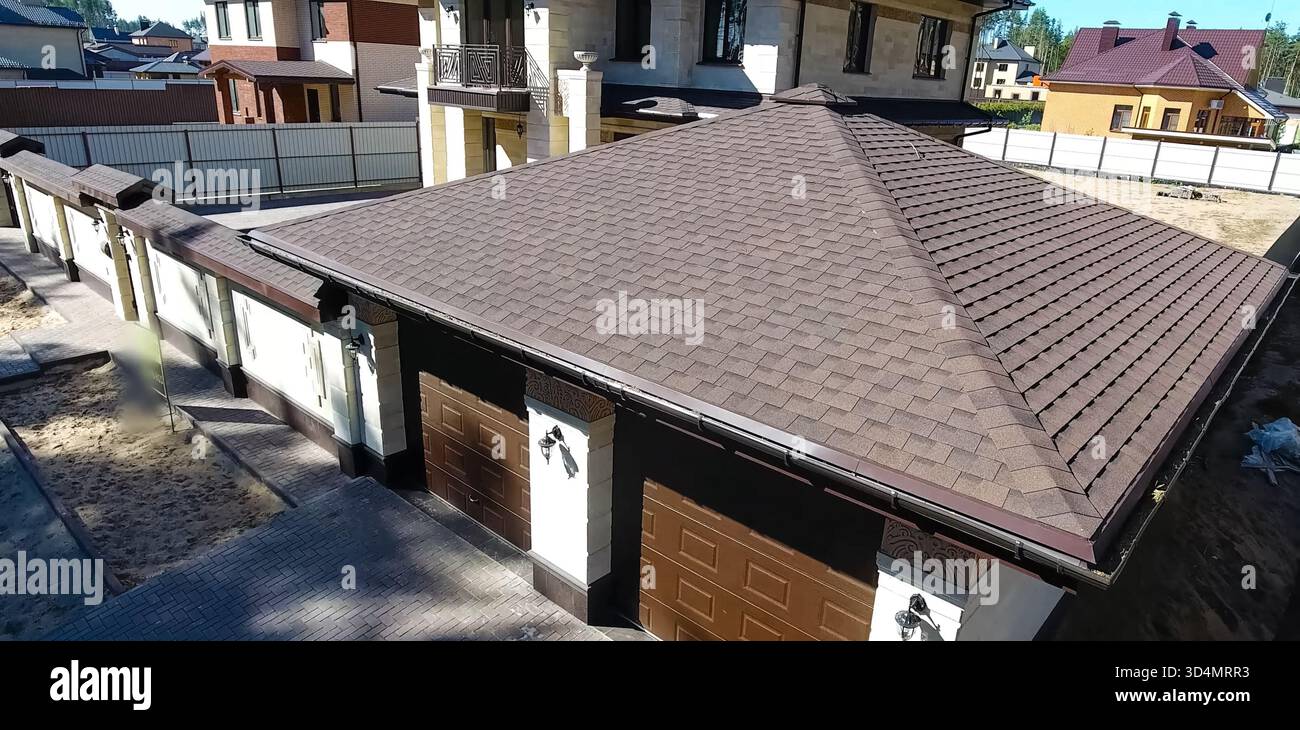 House with a roof from a bituminous tile. Bituminous tile for a roof. a ...