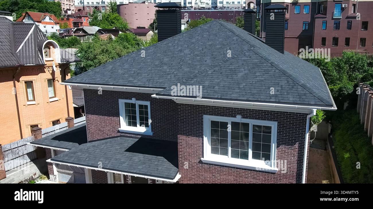 House with a roof from a bituminous tile. Bituminous tile for a roof. a ...
