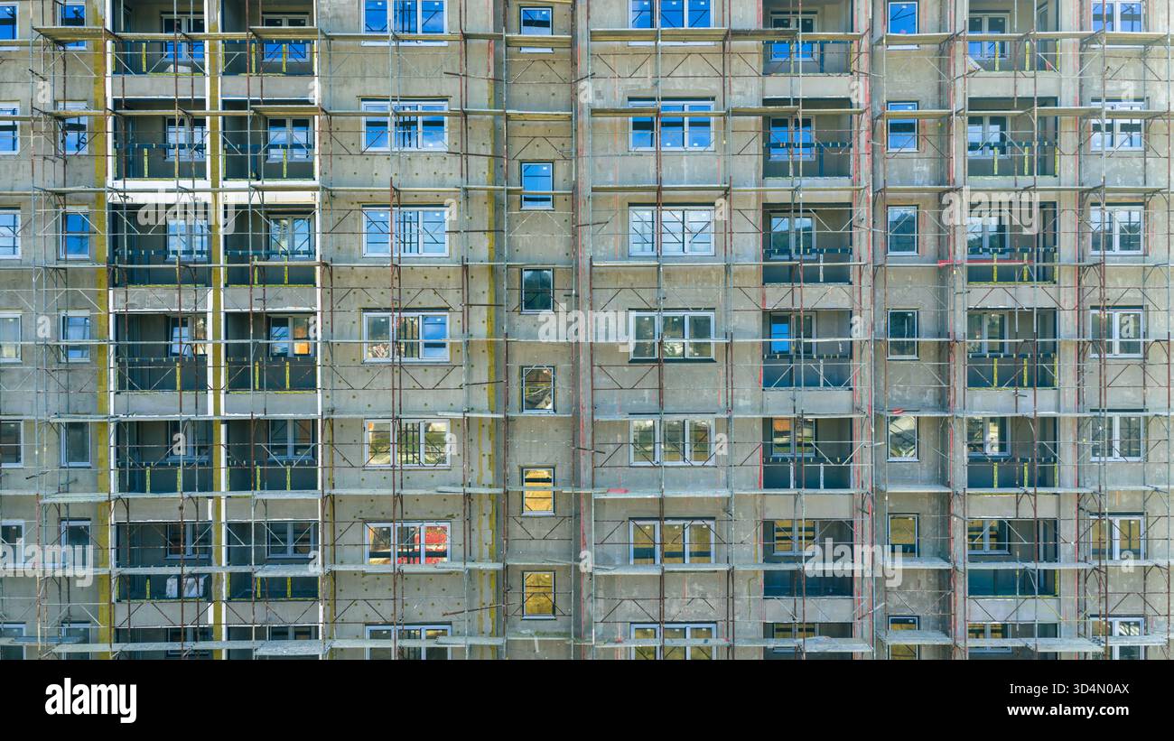 Facade of residential building under renovation with scaffolding and ...
