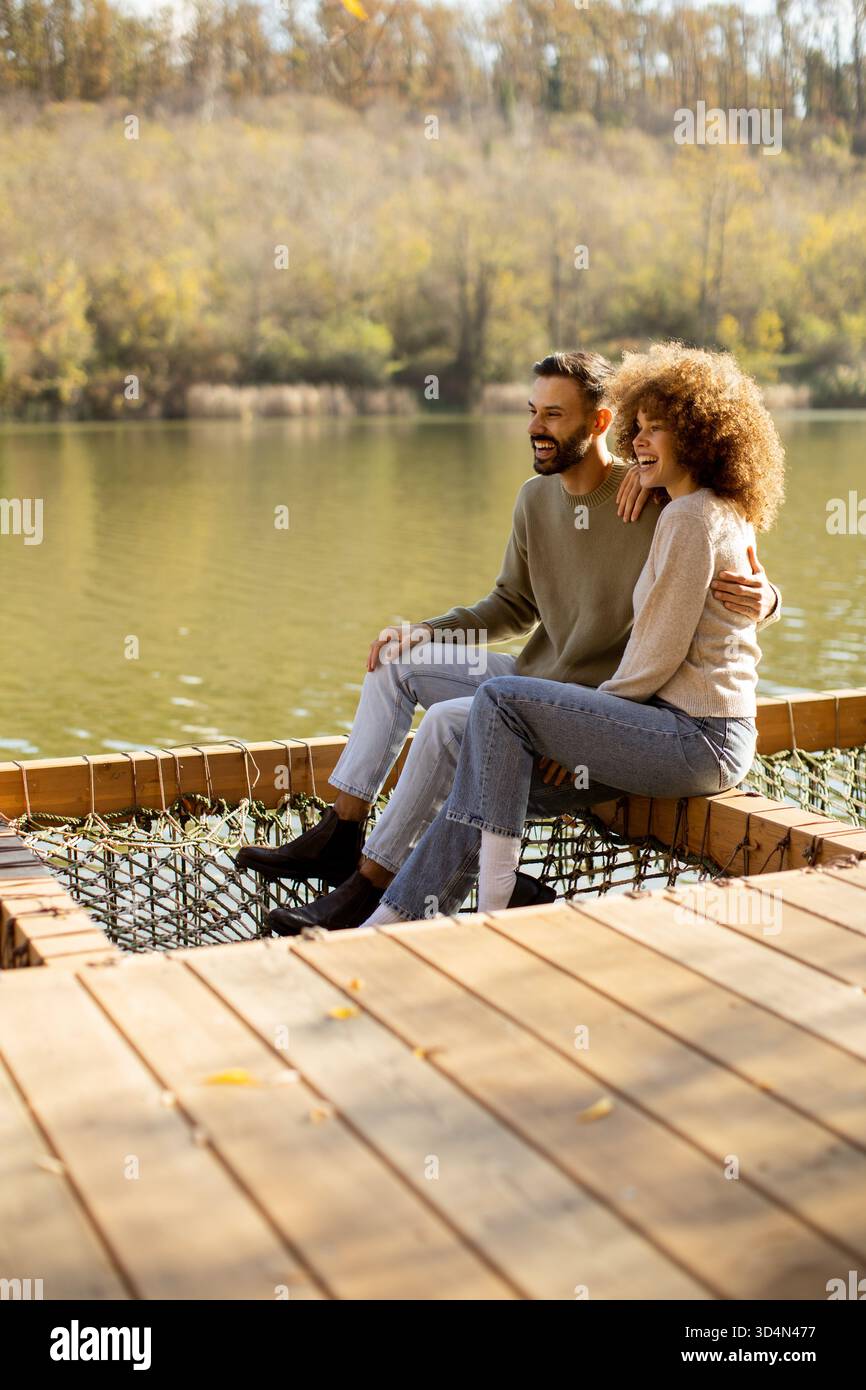 A couple enjoys a relaxed afternoon by the tranquil lake. They share ...