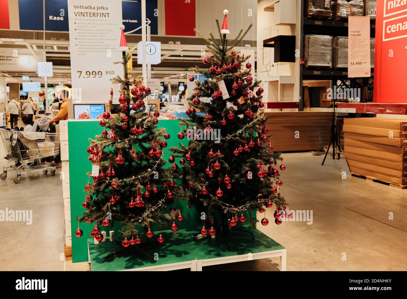 Small decorated Christmas trees with red ornaments and bows arranged in ...