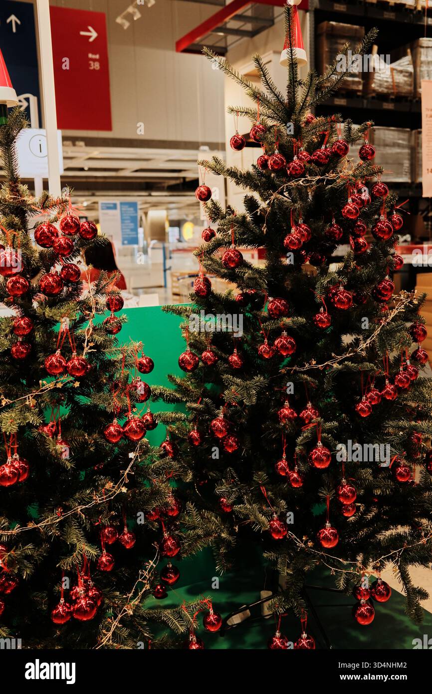 Small decorated Christmas trees with red ornaments and bows arranged in ...