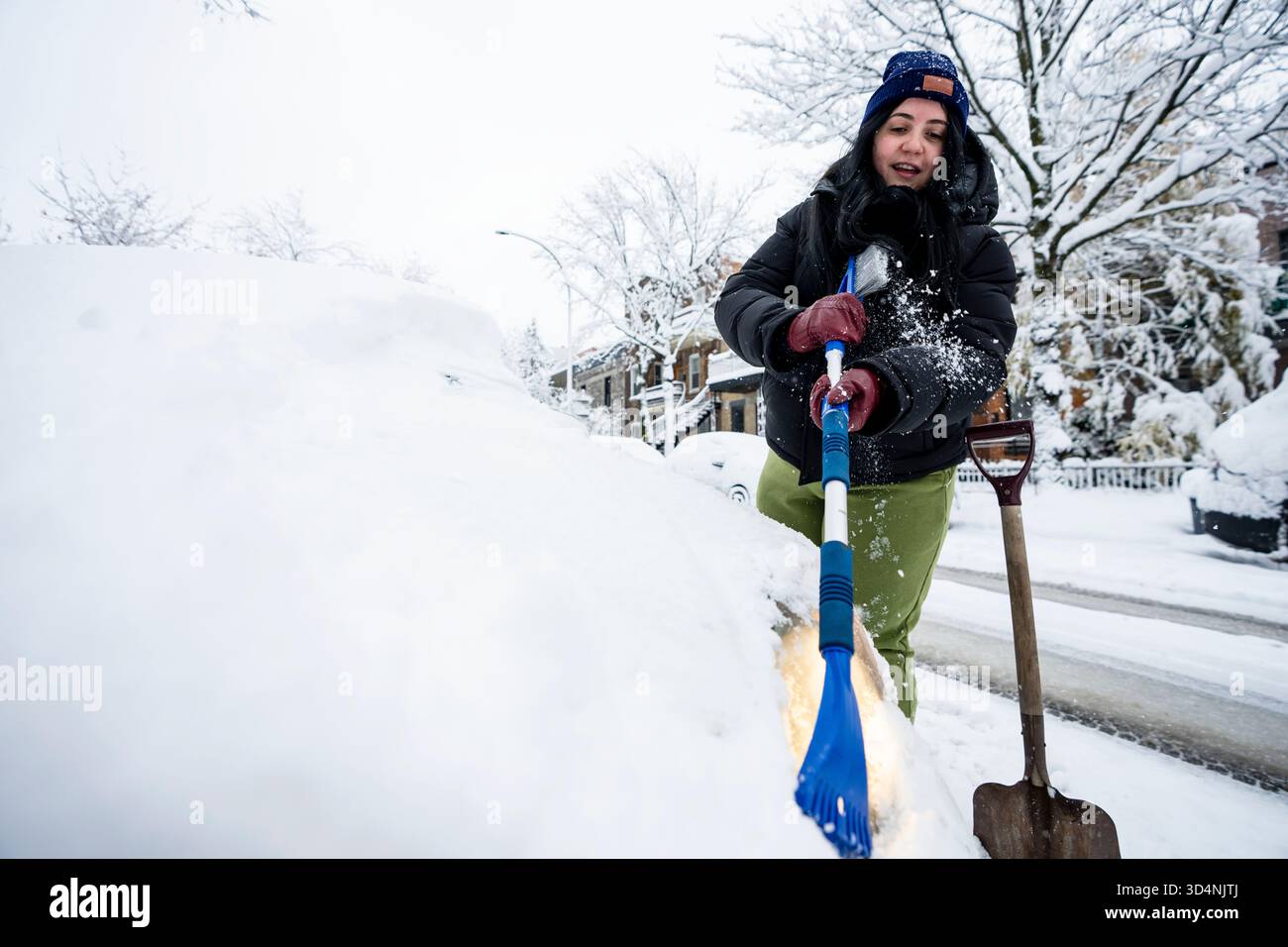 Genevieve Haspeck Lize enlève la neige sur sa voiture à Montréal, le ...