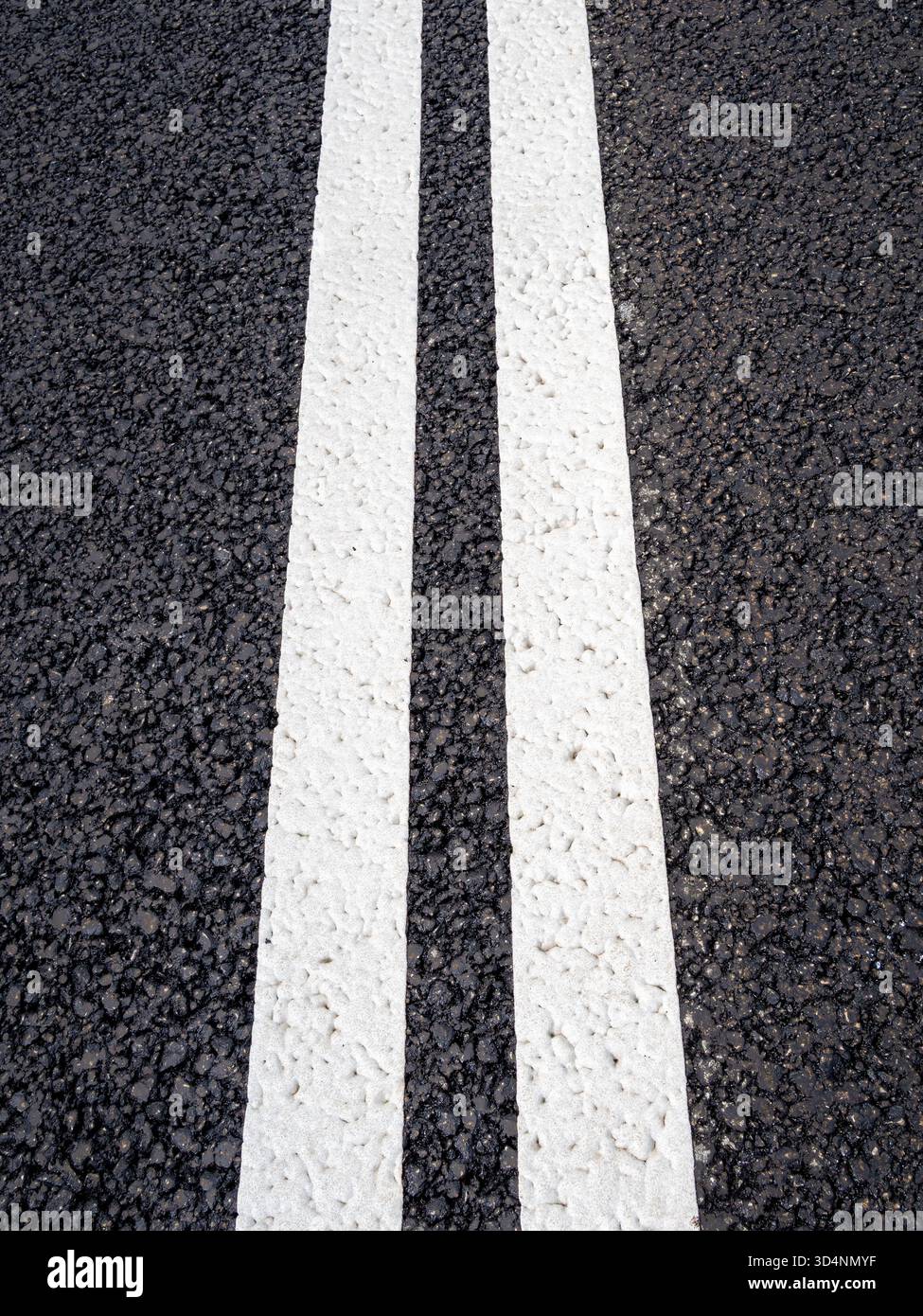 above view of freshly painted double solid lines on new asphalt surface ...