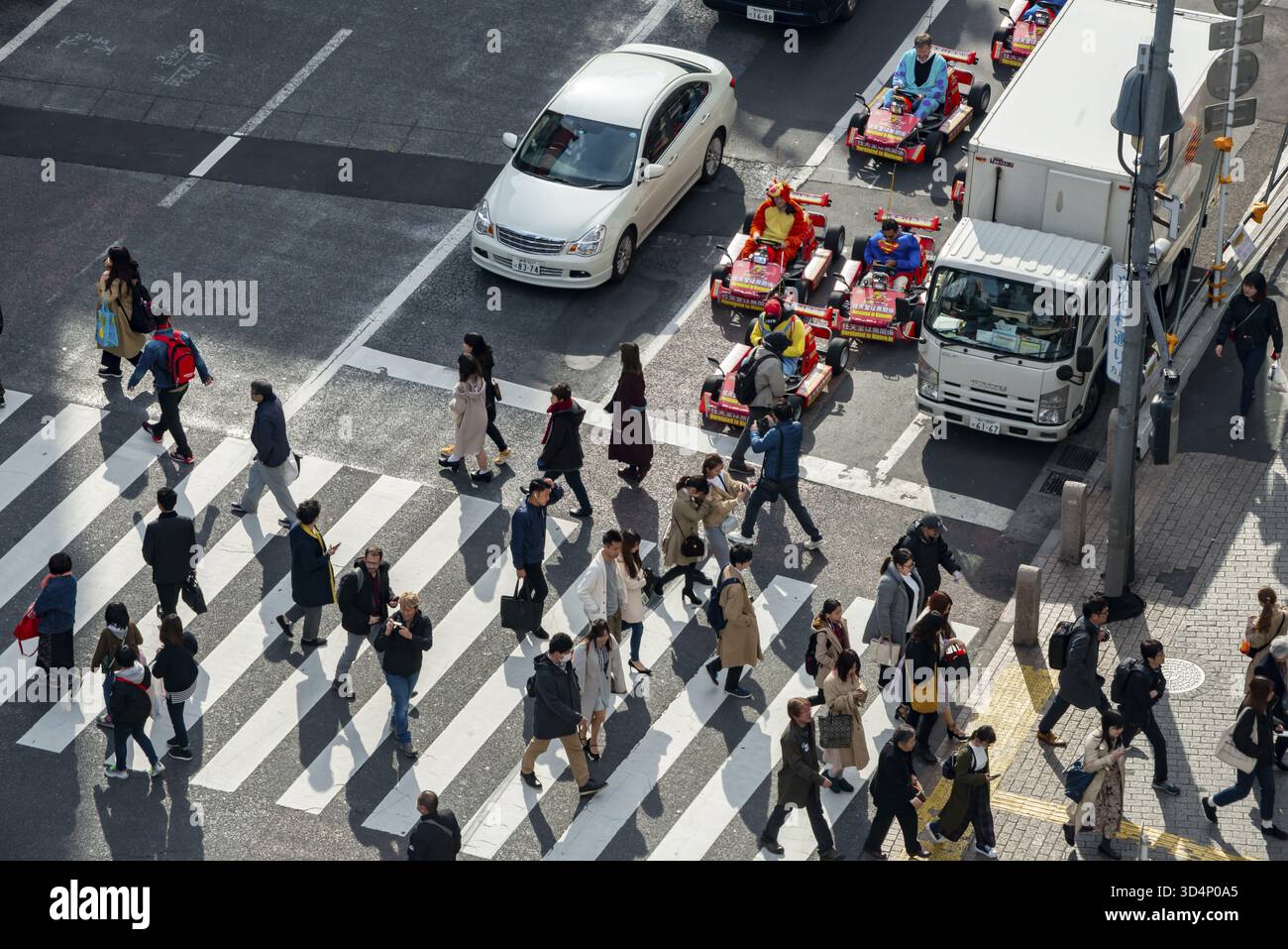 People cross zebra crossings, people in costumes ride small go-kart ...