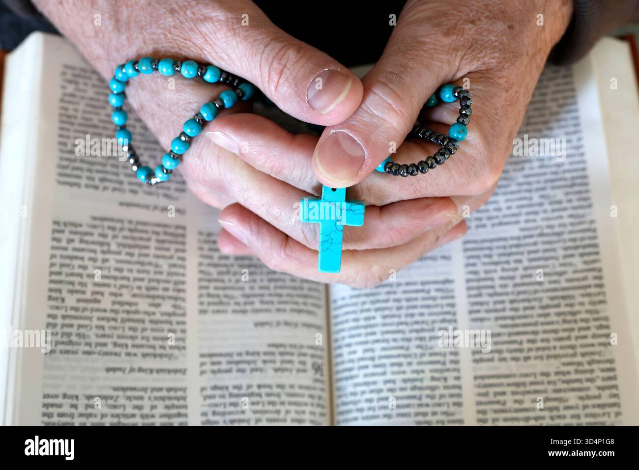 Man praying the rosary and the Bible at home. Man praying the rosary ...