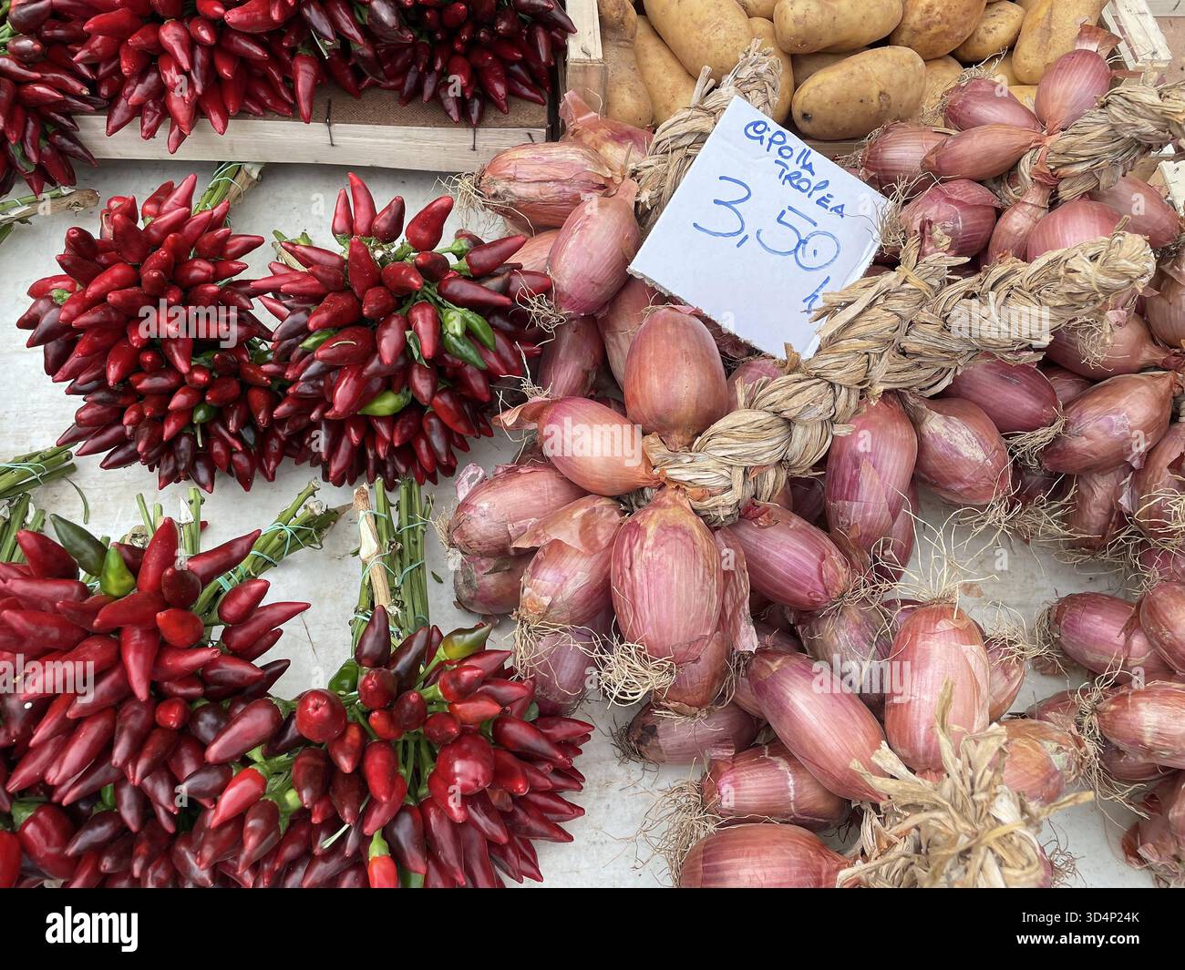 Chilies and shallots sold on a market in Andrano, Italy. Chilies and ...