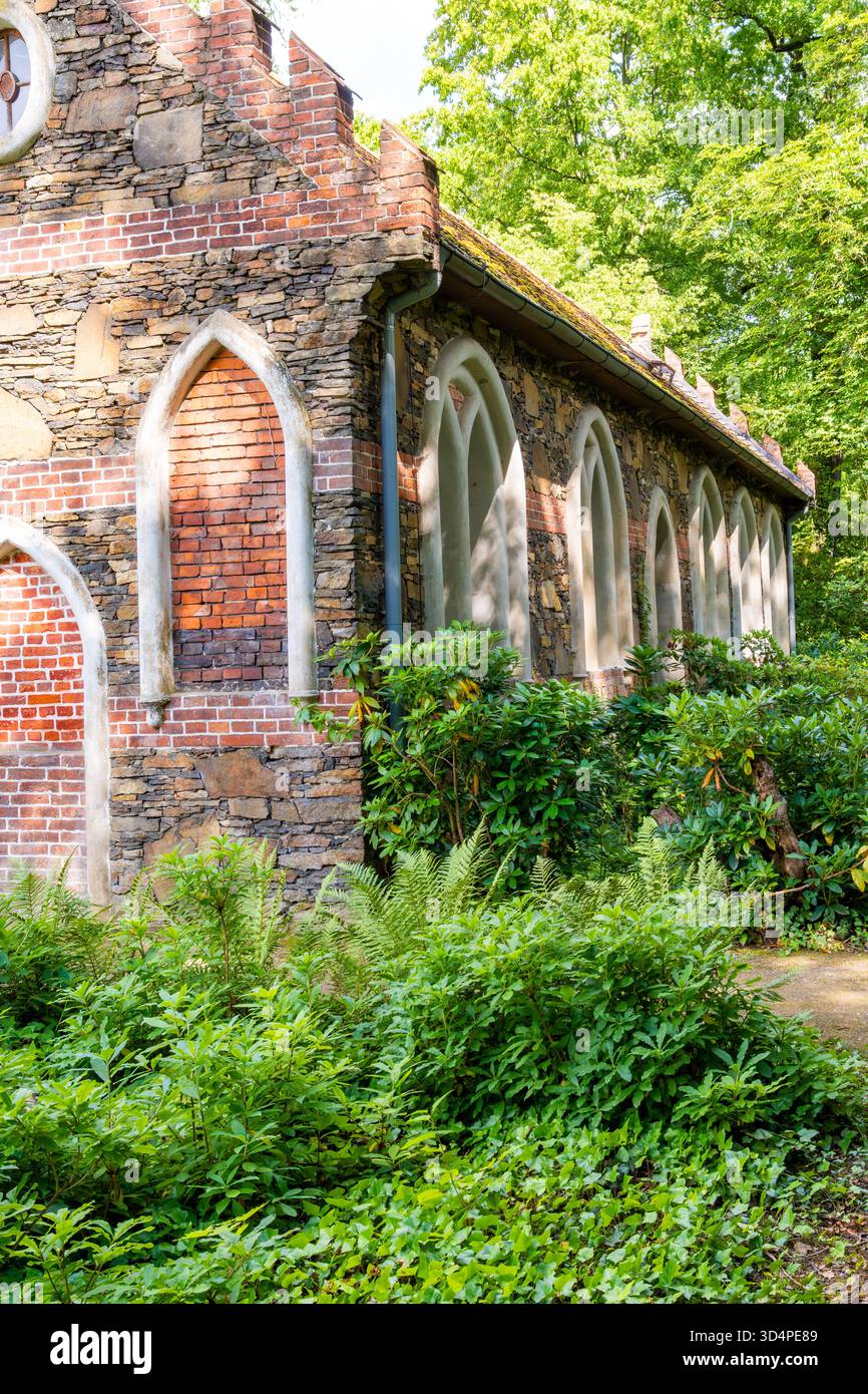 Close-up view of a historic brick chapel wall surrounded by lush green ...