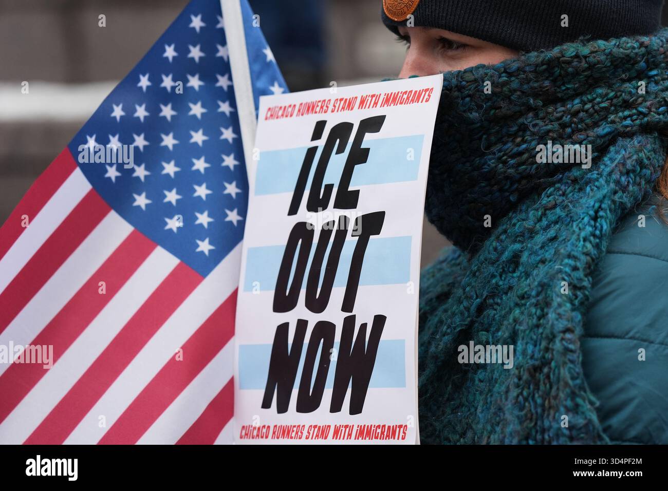 A protester holds a sign and a flag during a Veterans Day protest in ...