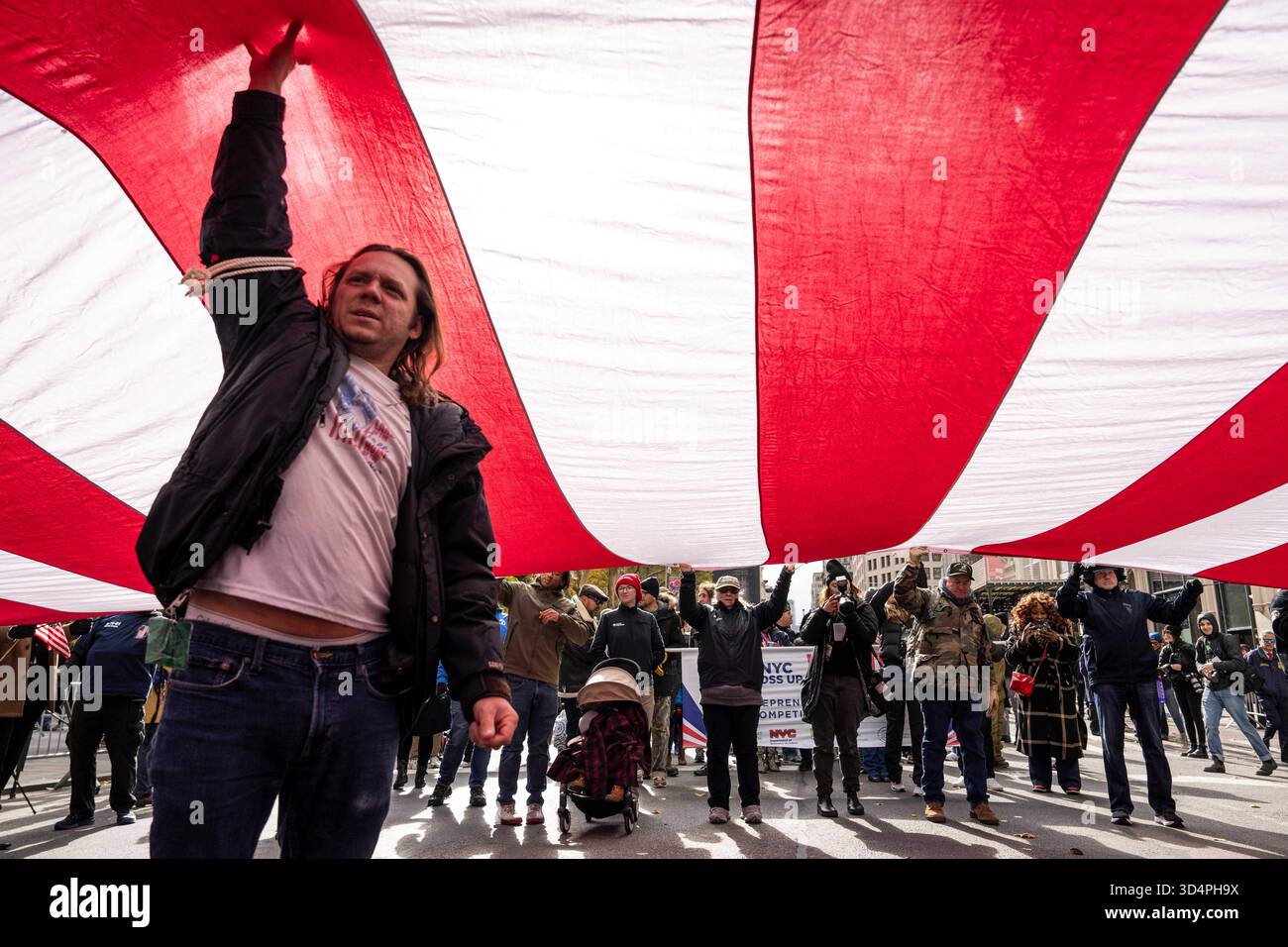 Participants raise an American flag during the Veterans Day parade ...