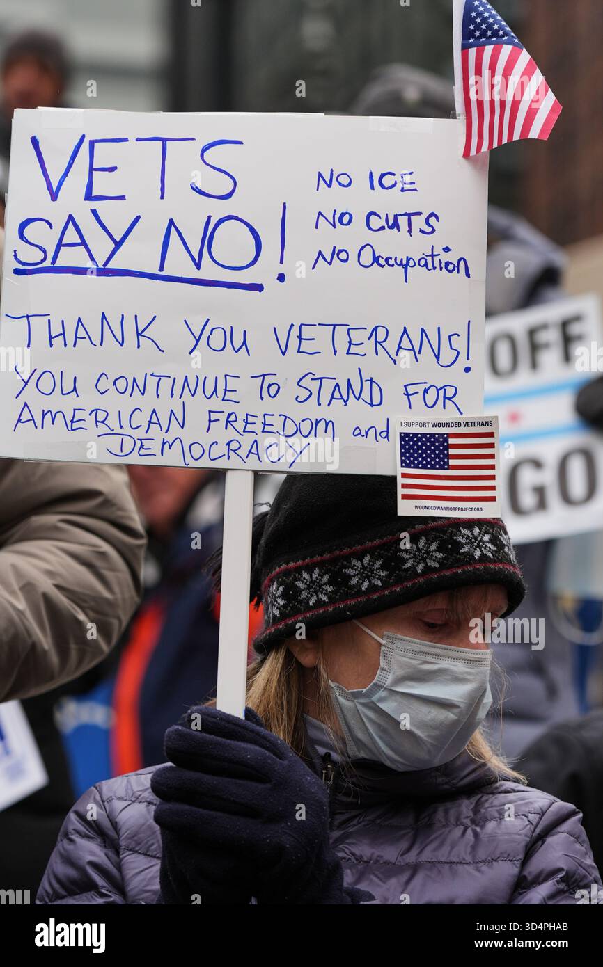 Maureen Harazin holds a sign and a flag during a Veterans Day protest ...