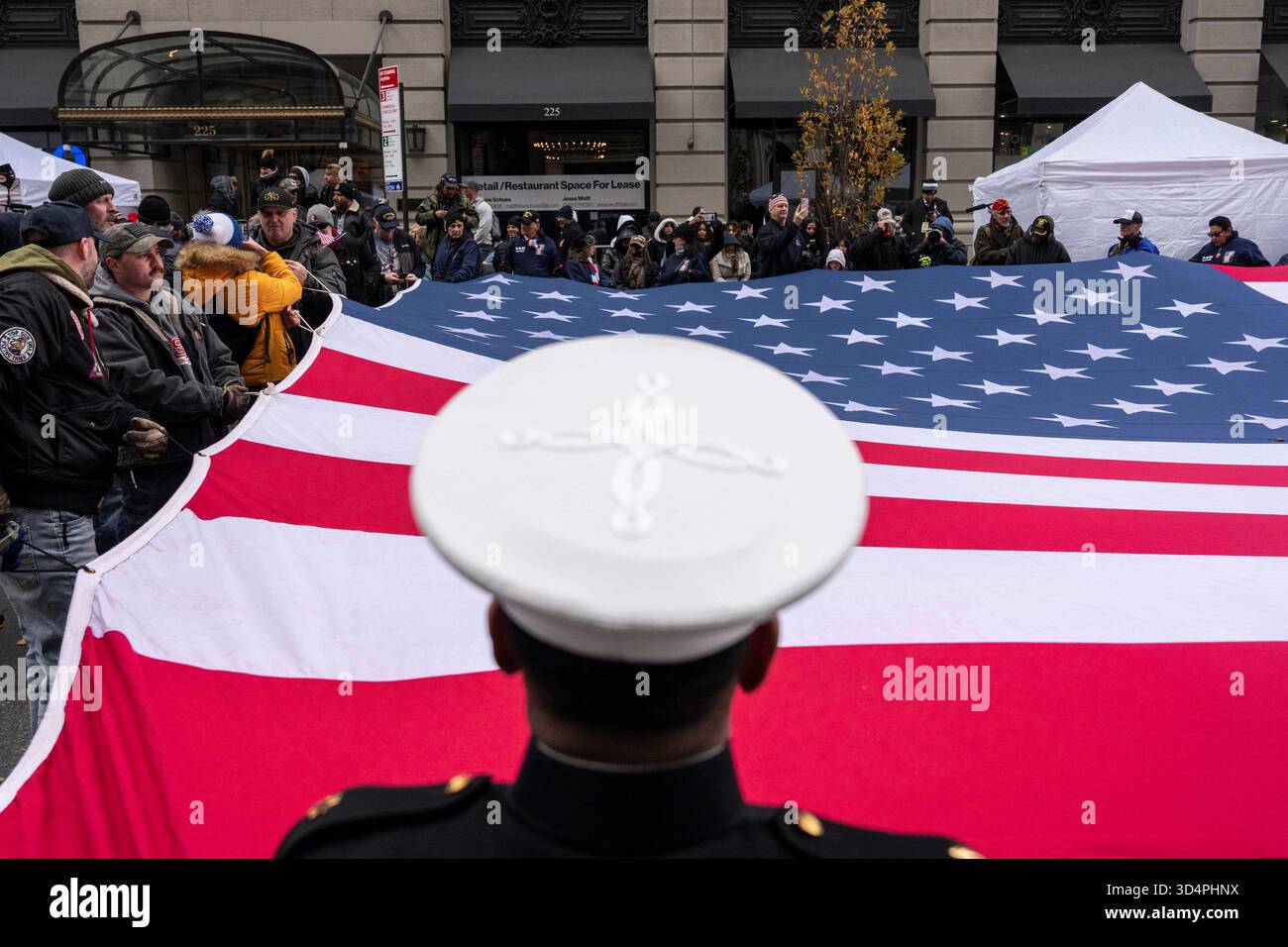 U.S. Marine Corps member helps hold an American flag during the ...