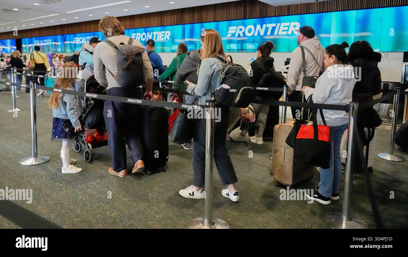 Passengers check in at the Frontier airlines counter at Orlando ...