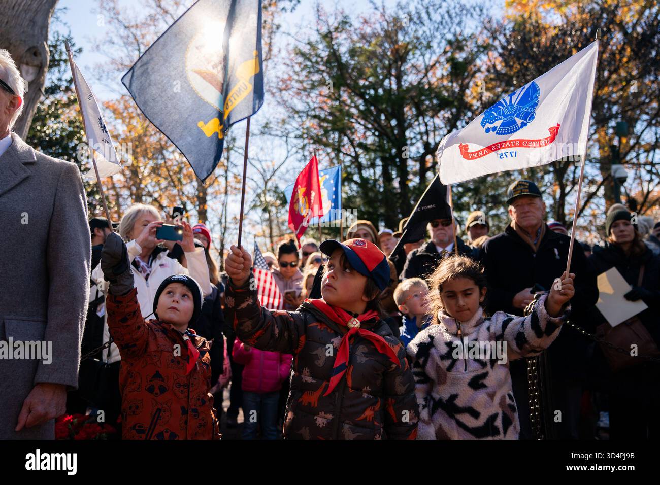 Evren Sanchez, 6, and other Cub Scouts hold their flags up during a ...