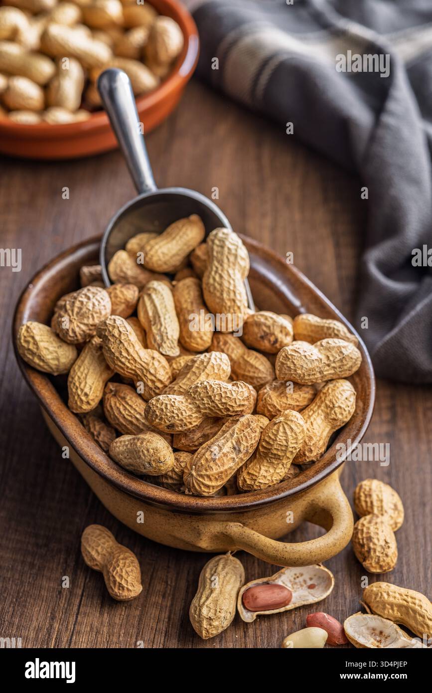 Peanuts in shell. Groundnuts in bowl on a wooden table Stock Photo - Alamy