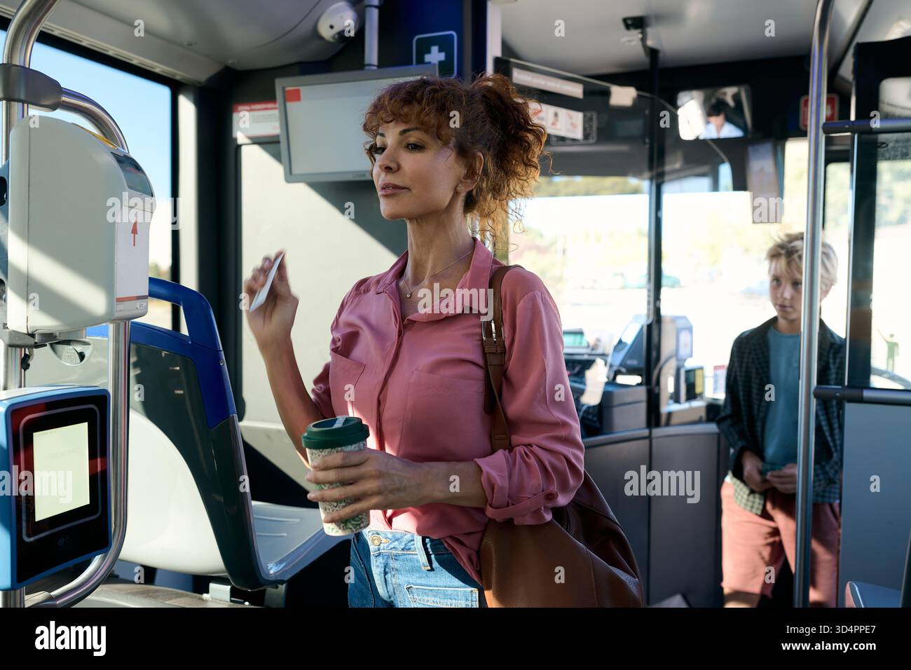 Woman paying bus fare using ticket with boy Stock Photo - Alamy