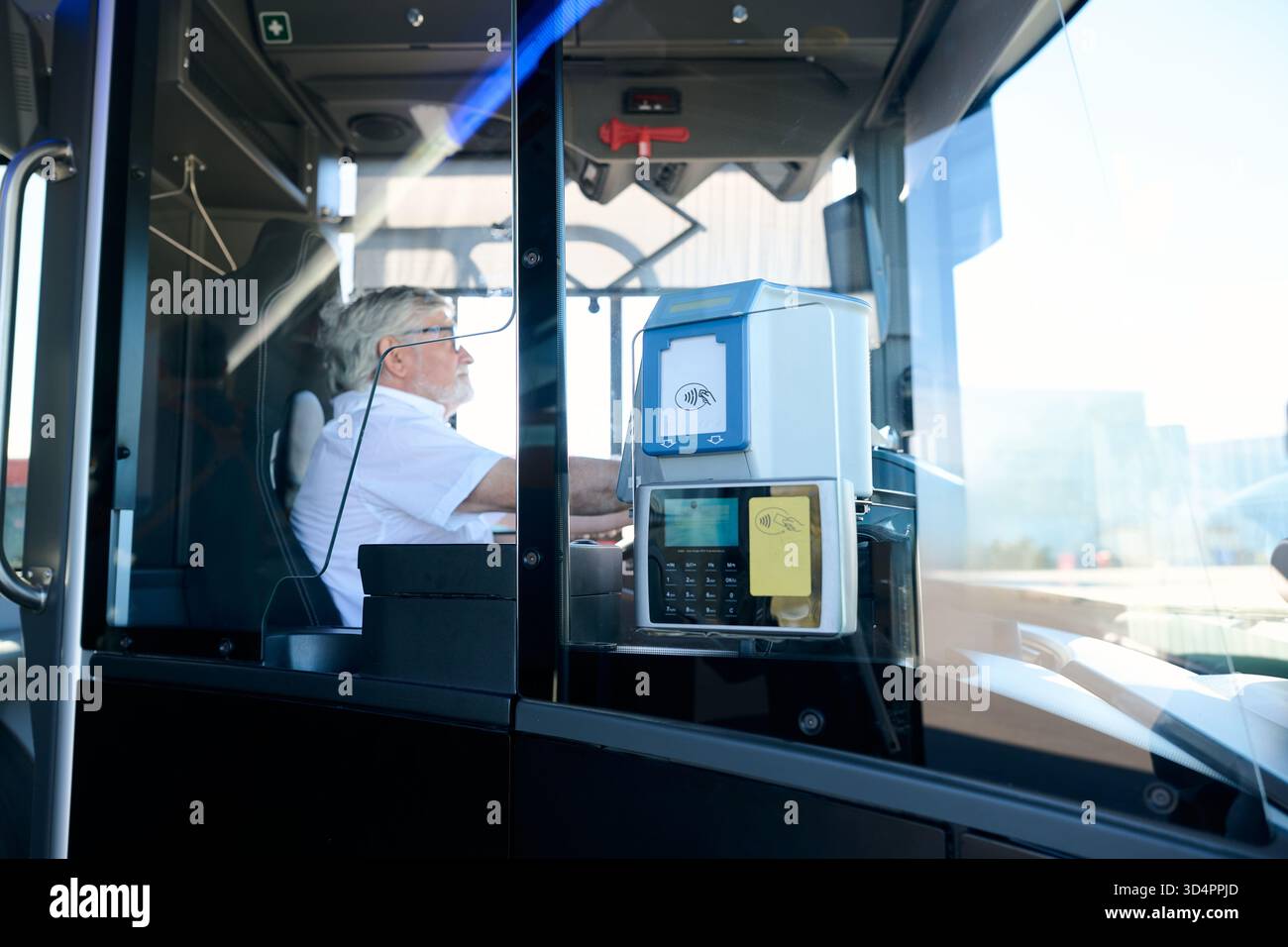 Senior bus driver operating public transport with ticket machine Stock ...