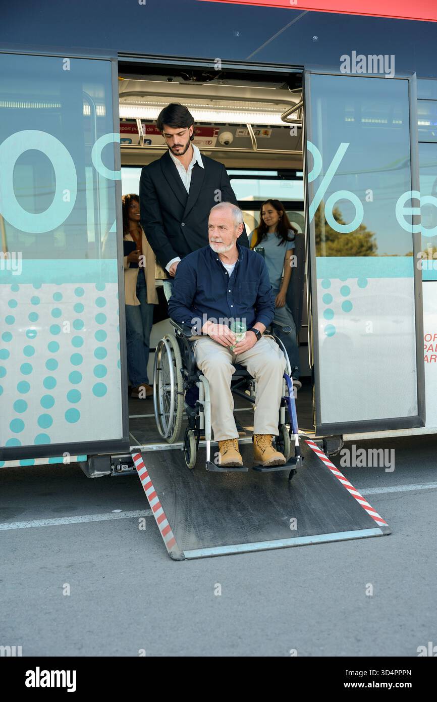 Man in wheelchair exiting public bus with ramp Stock Photo - Alamy