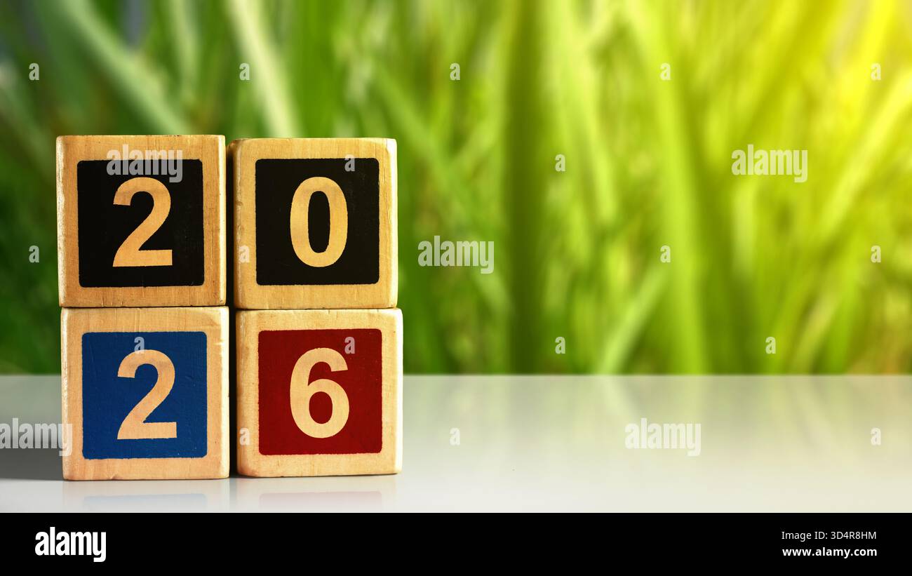 Stack of wooden cubes with the number 2026 on the table with blurred ...