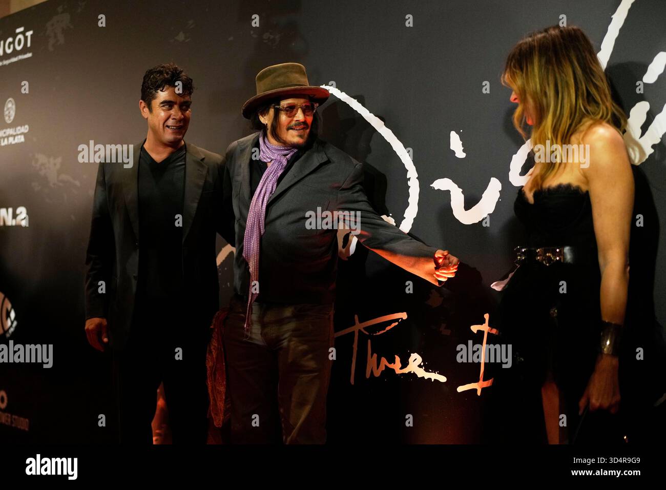 American director Johnny Depp, center, and Italian actor Riccardo Scamarcio, left, chat with ...