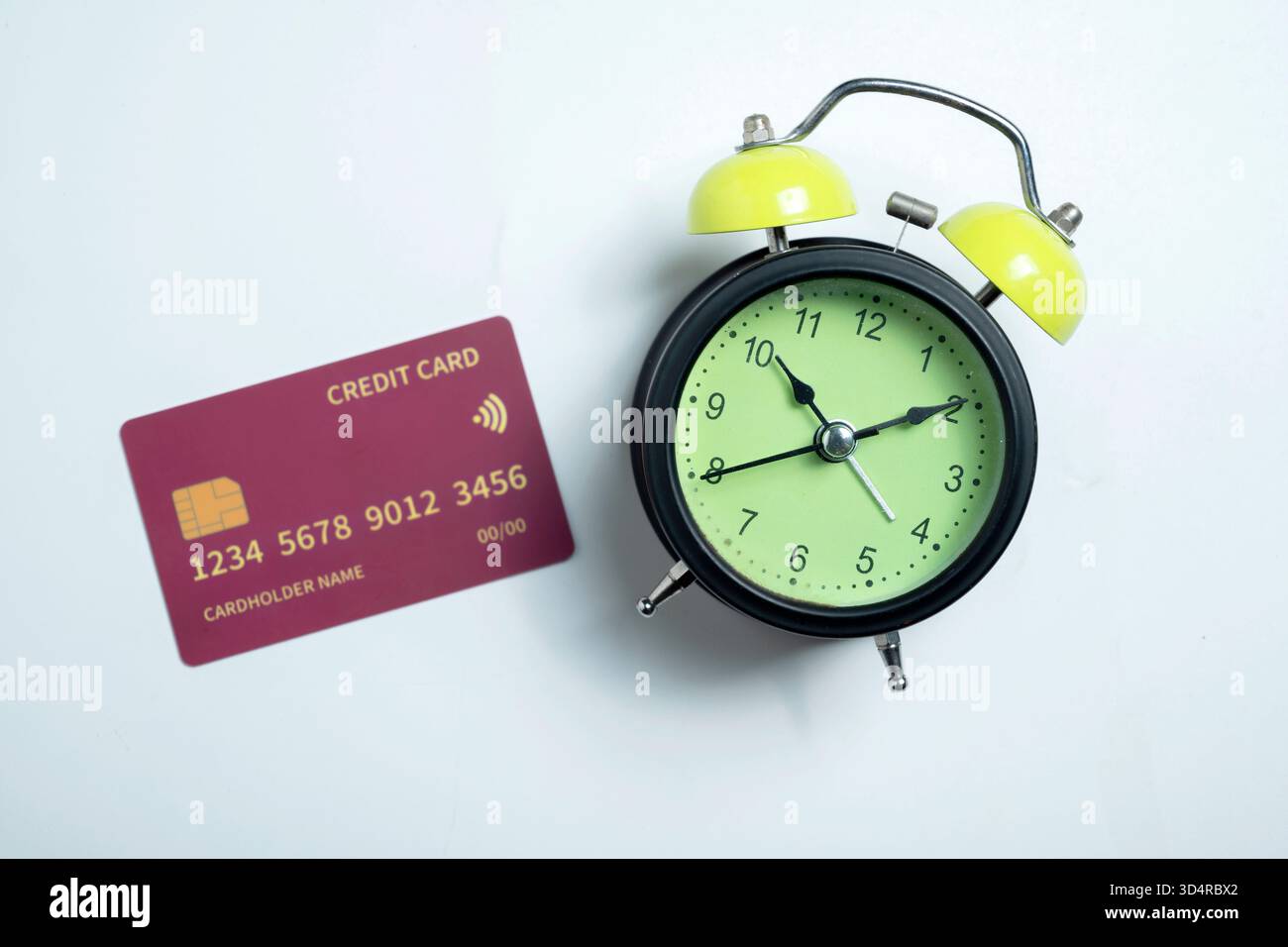 Credit card and alarm clock on a white background. Concept of finance ...