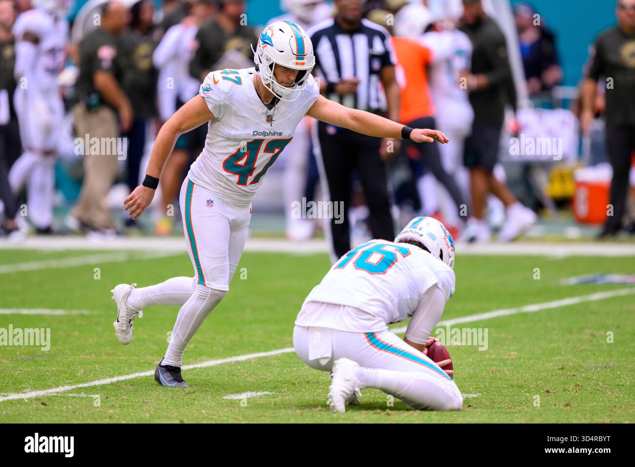 Miami Dolphins punter Jake Bailey (16) holds the ball as kicker Riley ...