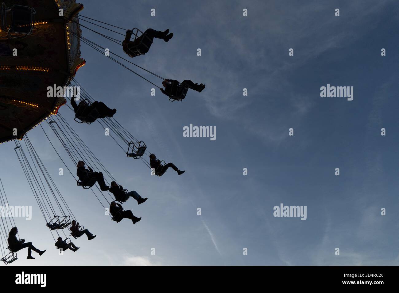 November 11, 2025, Hochheim, Hesse, Germany: Visitors ride a swing ...