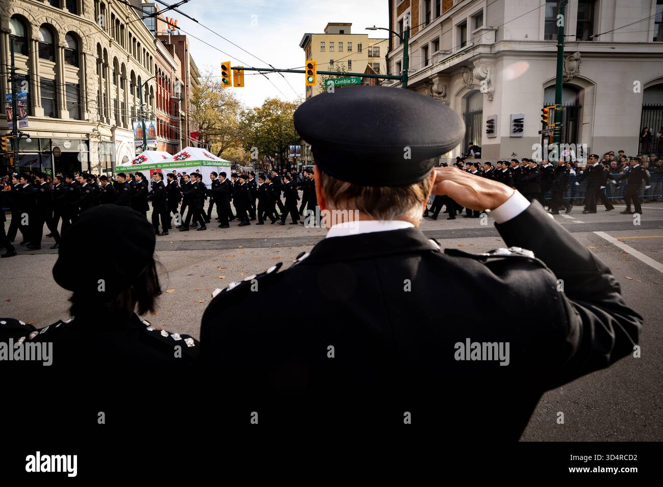 A man salutes as people march by in a parade during a Remembrance Day ...