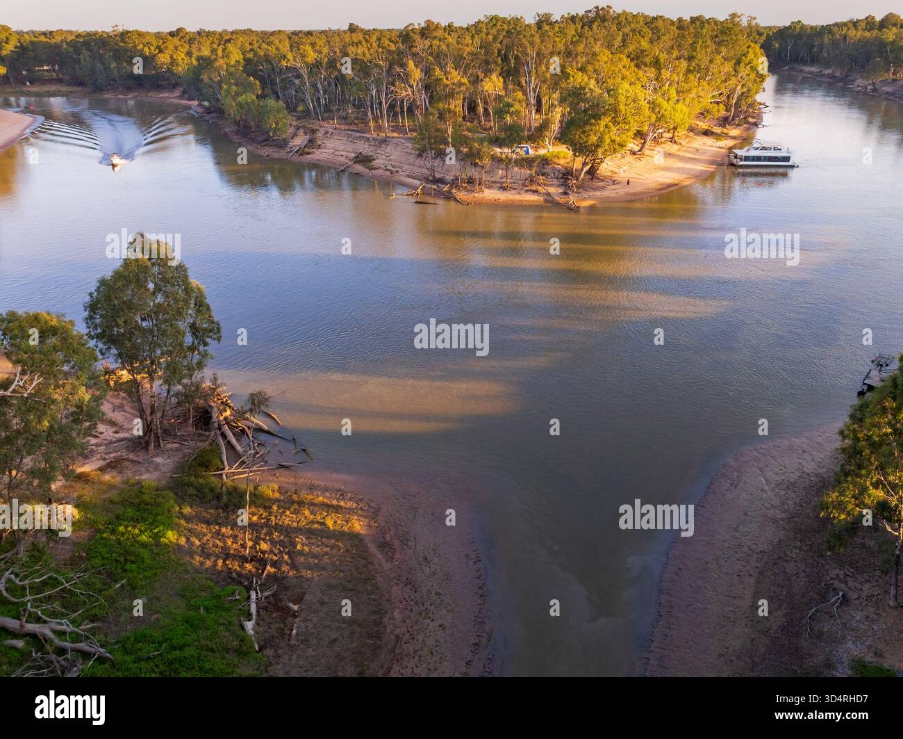Aerial view of a speedboat and a houseboat on a wide river bend at ...