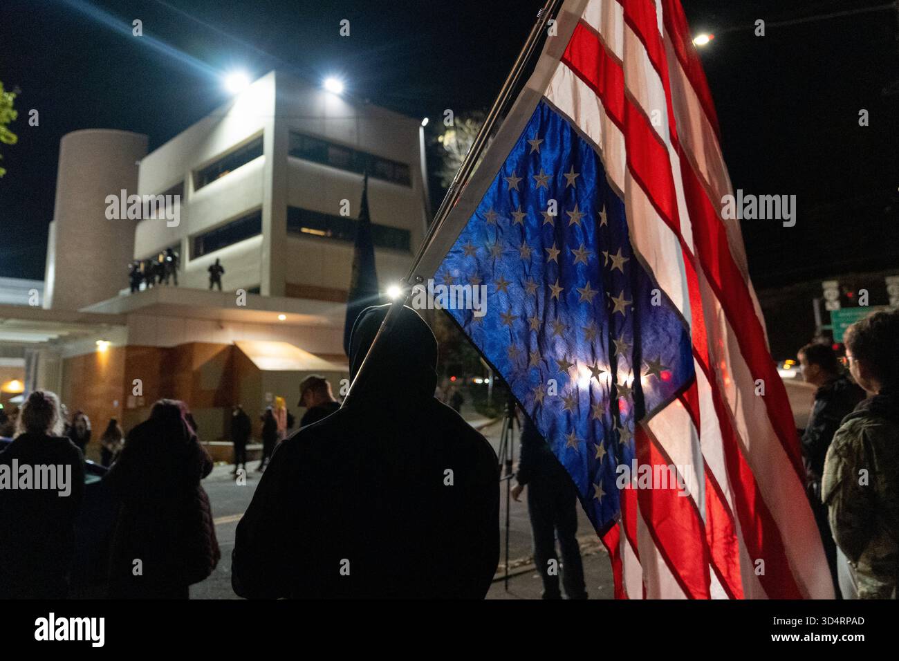 A person holds an American flag outside a United States Immigration and ...