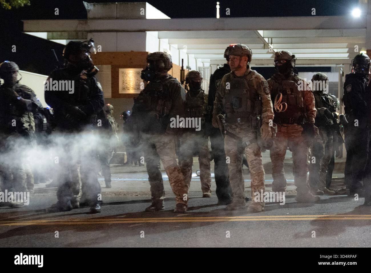 Federal officers line the street to guard vehicles leaving a United ...