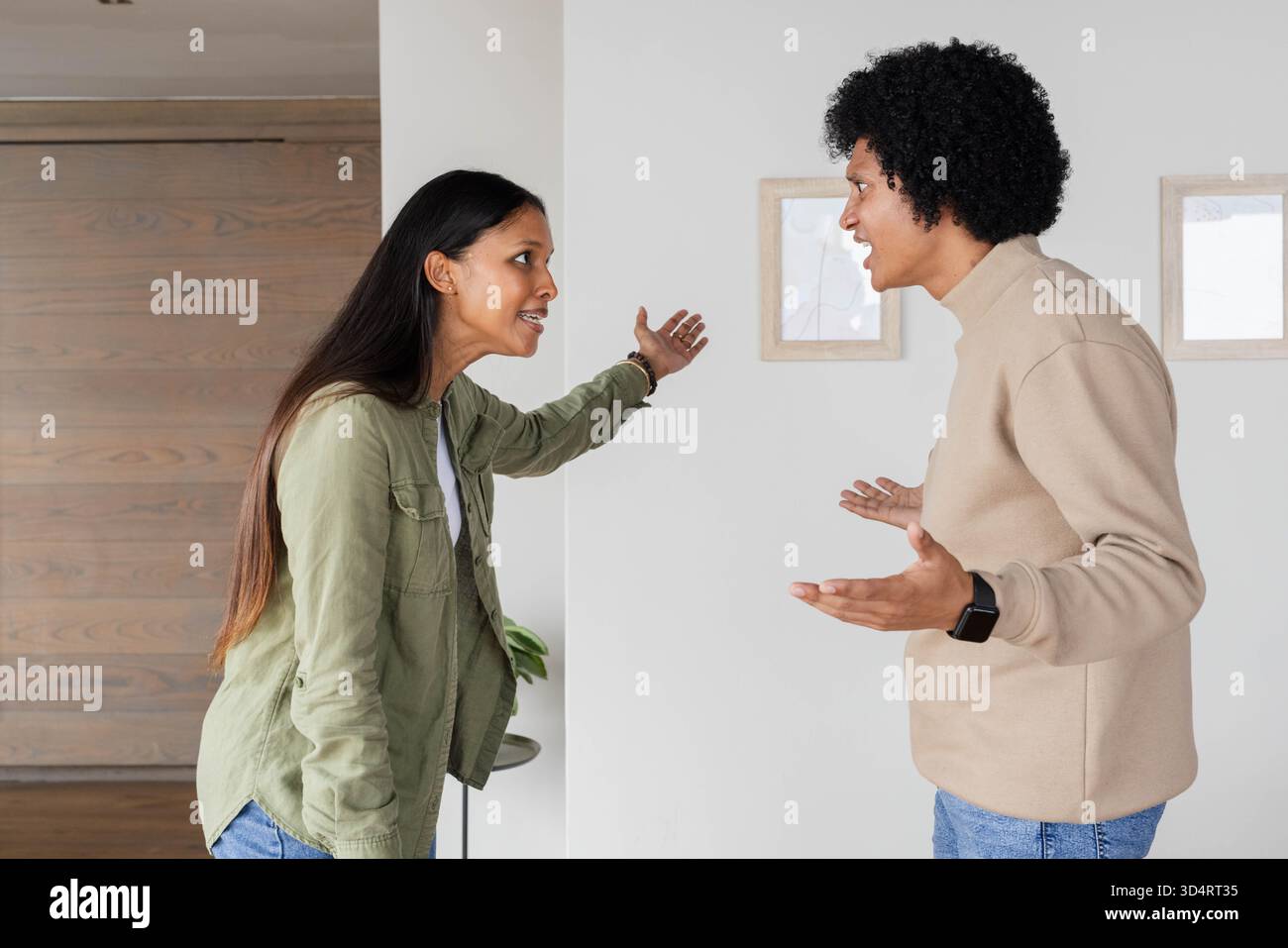 Arguing diverse couple expressing disagreement at home, with smartwatch ...