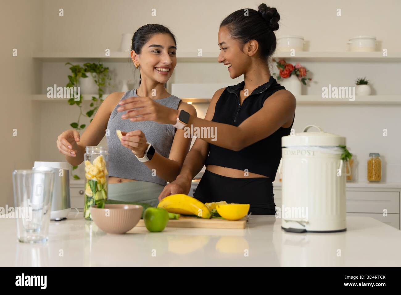 Cutting bananas Diverse female friends preparing smoothie on kitchen ...
