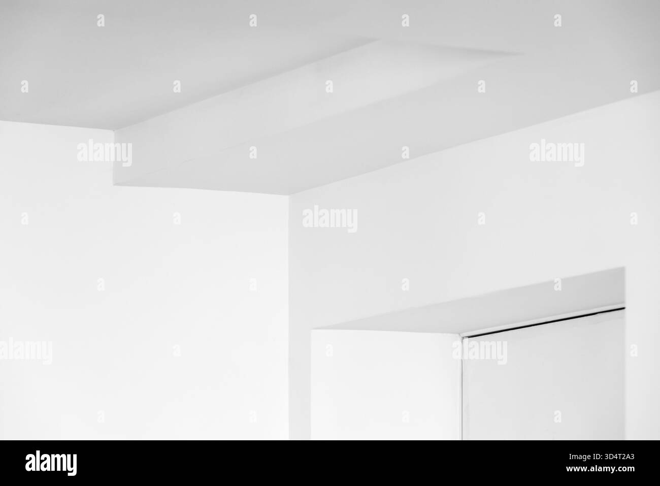 A clean, minimalist white interior featuring a sharp corner and a door ...