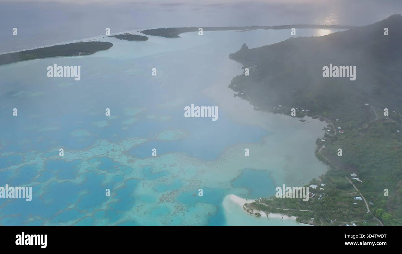 Aerial view of the stunning Bora Bora lagoon at sunrise, with a thin ...