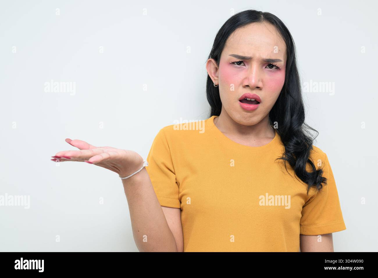 Studio portrait of a young Thai transgender individual with makeup and ...